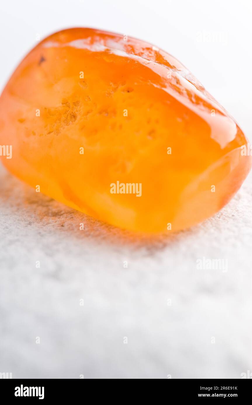 Natural stone carnelian shines in beautiful colours on a white ...