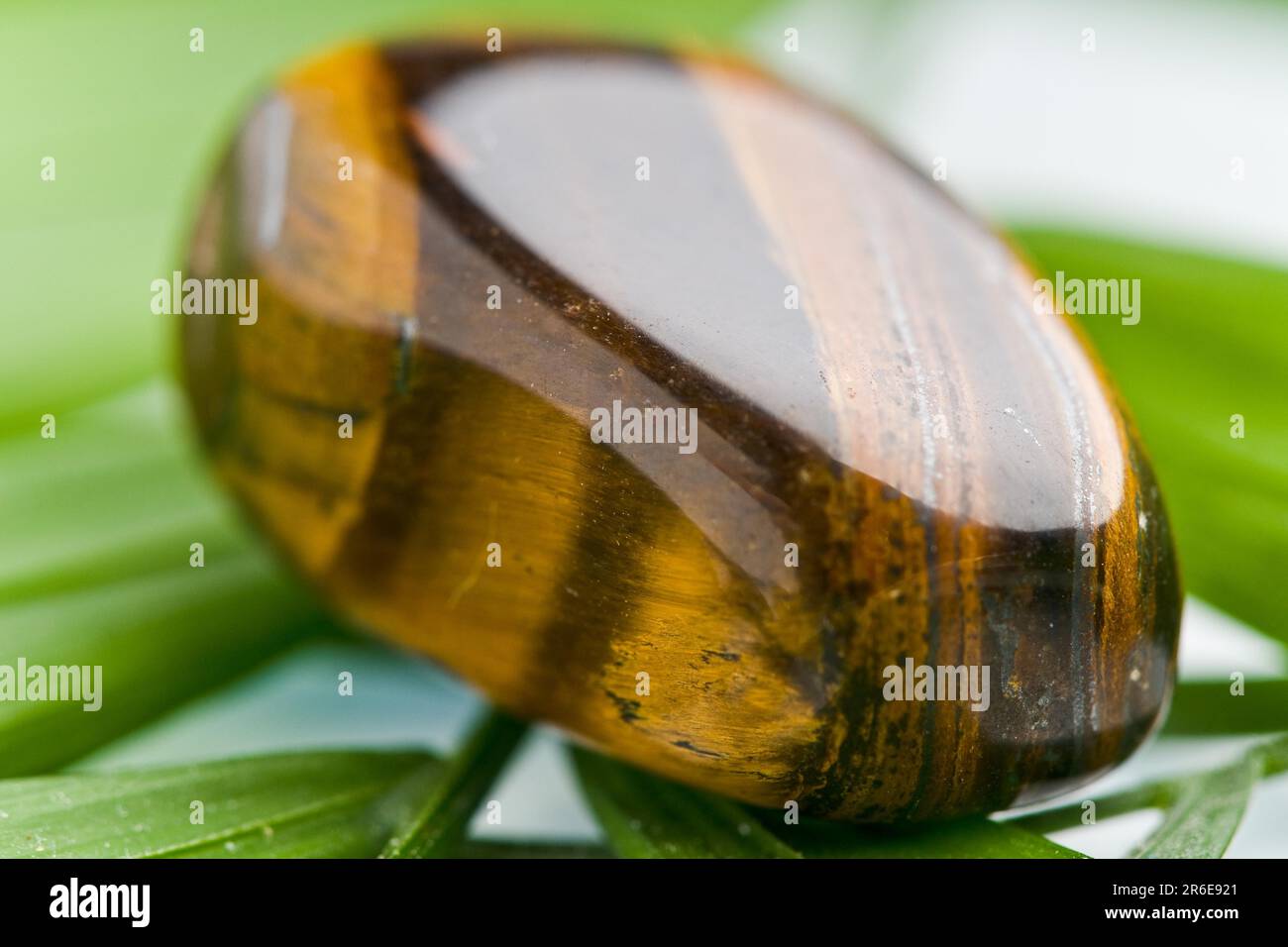 Natural stone tiger iron, shines in beautiful colours on a white ...
