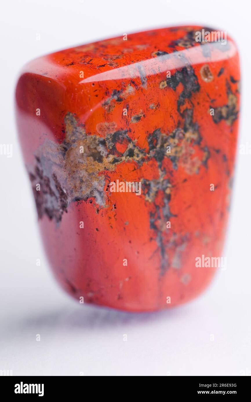 Natural stone red jasper shines in beautiful colours on a white ...
