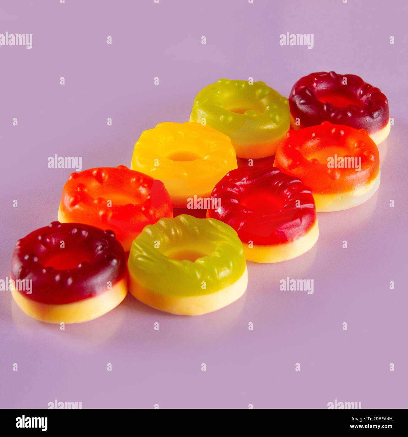 Eight round jelly candies lie on purple background. Sugary, circular ...