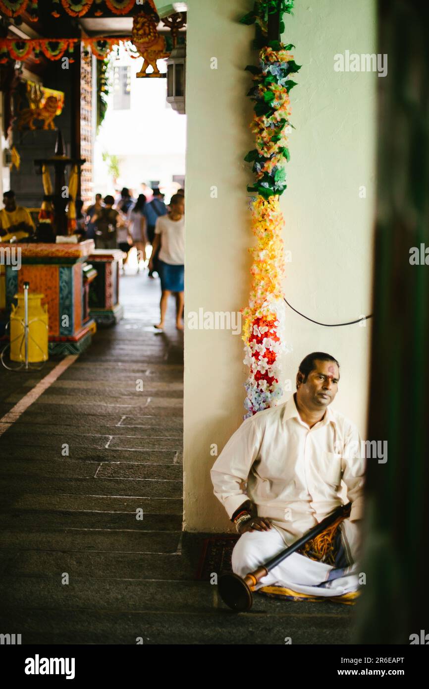 Man worships in Hindu temple with colorful flower boa Stock Photo - Alamy