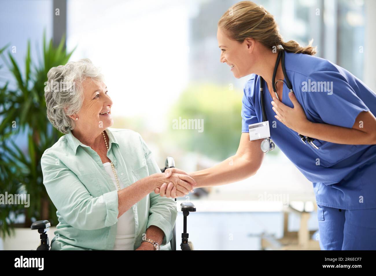Handshake, nurse and senior advice in wheelchair with medical results ...