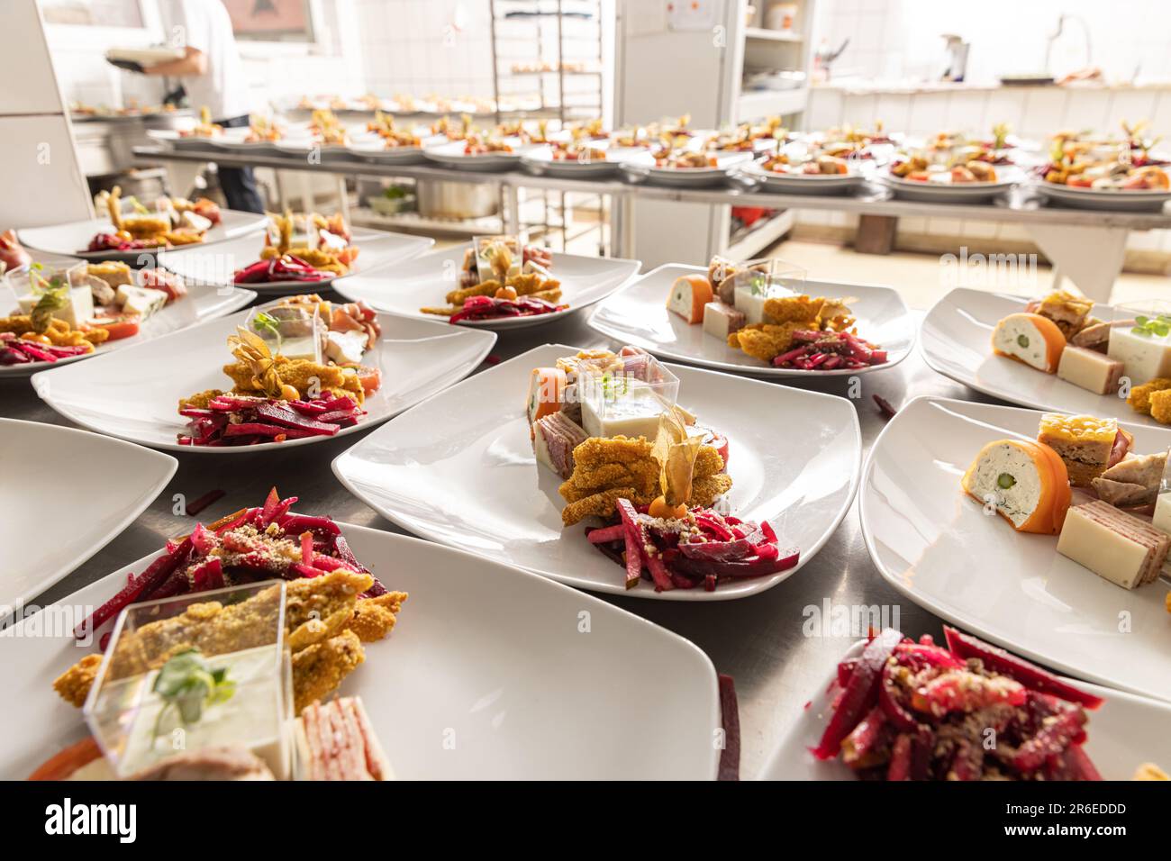 Many plates of appetizers being prepared in commercial kitchen for ...