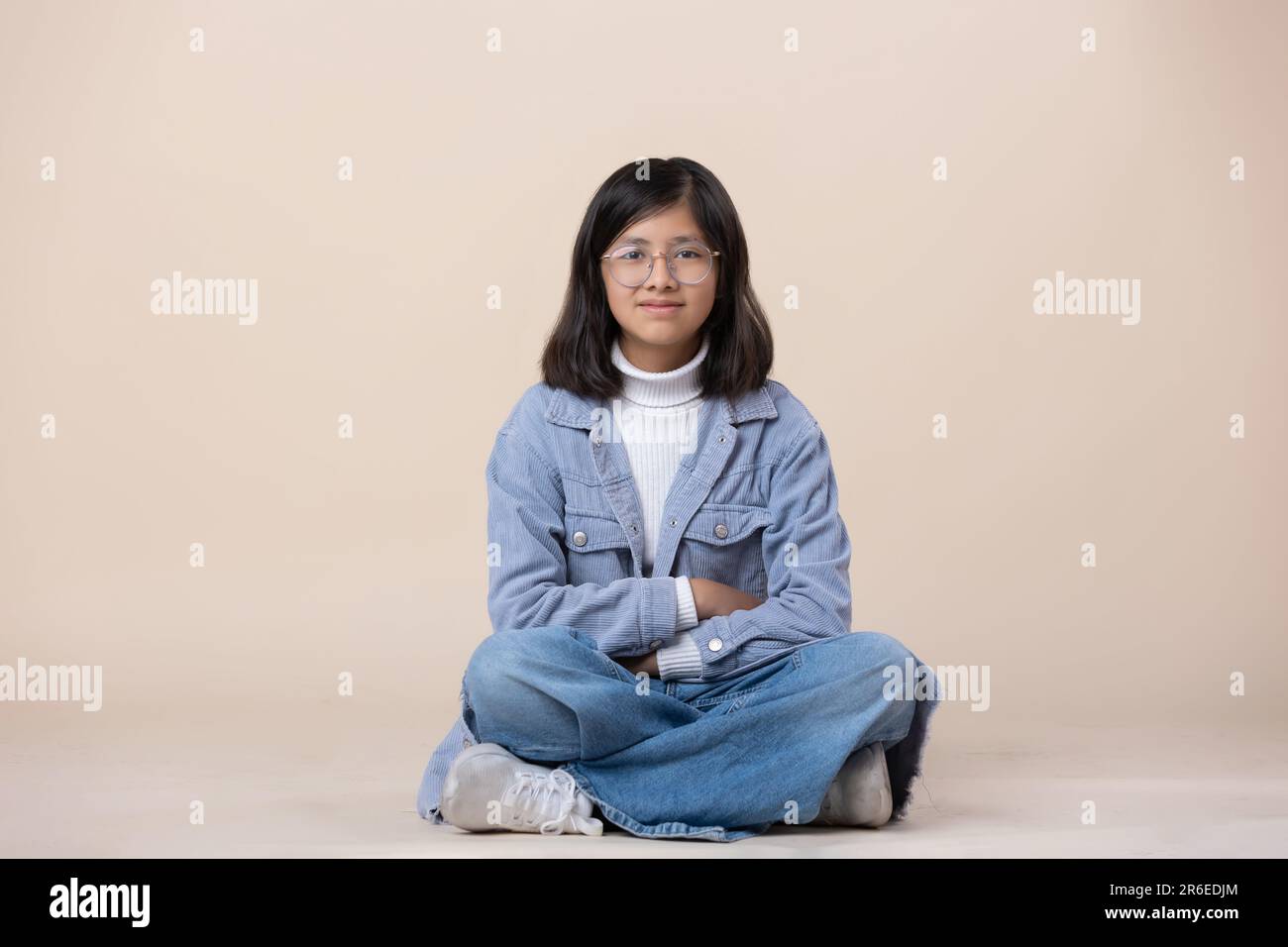 An Asian woman poses for the camera while seated, her expression ...