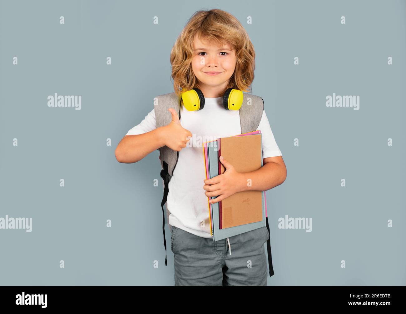 Portrait of pupil student hold book on grey isolated studio background ...