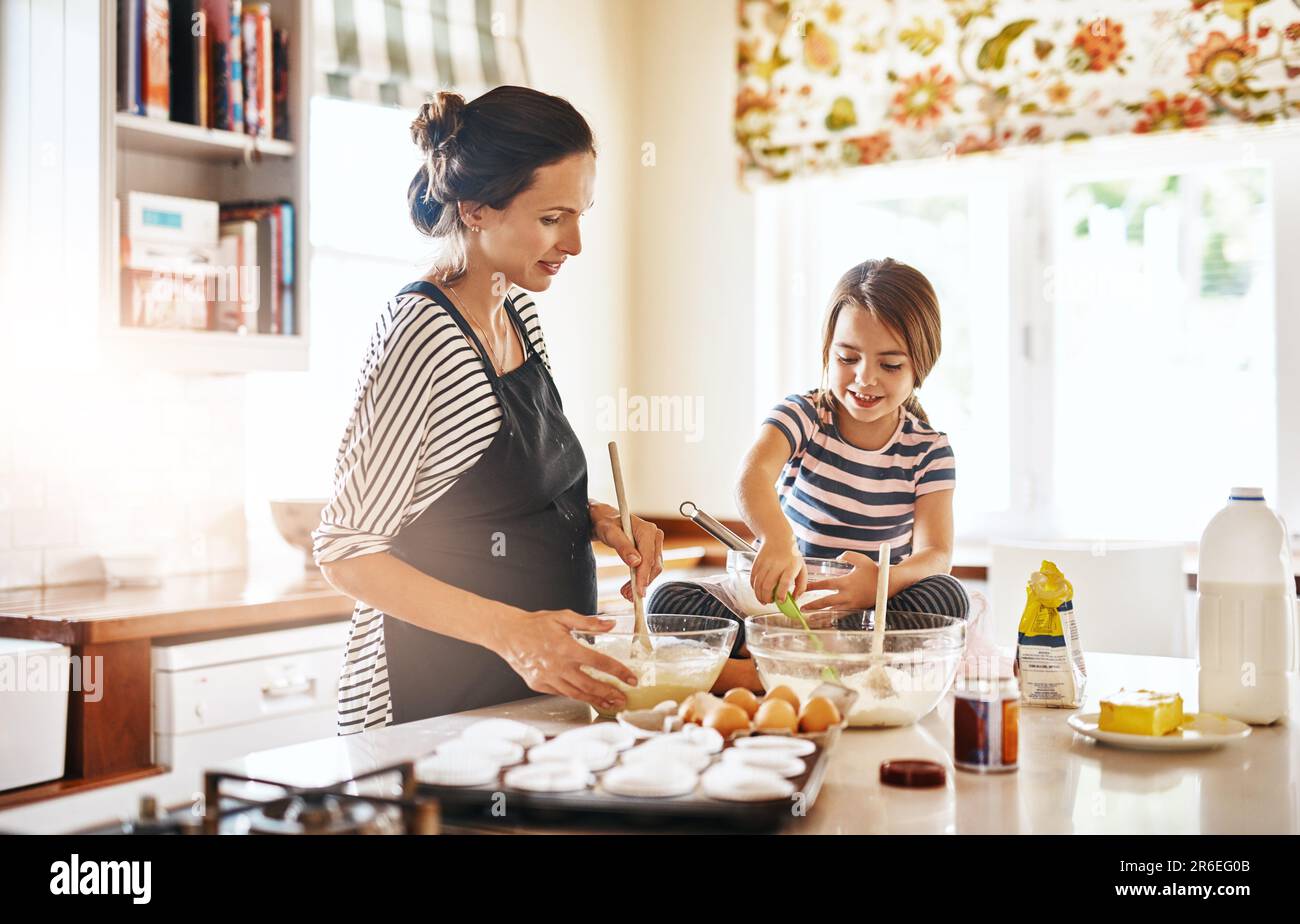 Mom cooking or girl child baking in kitchen as a family with a young ...