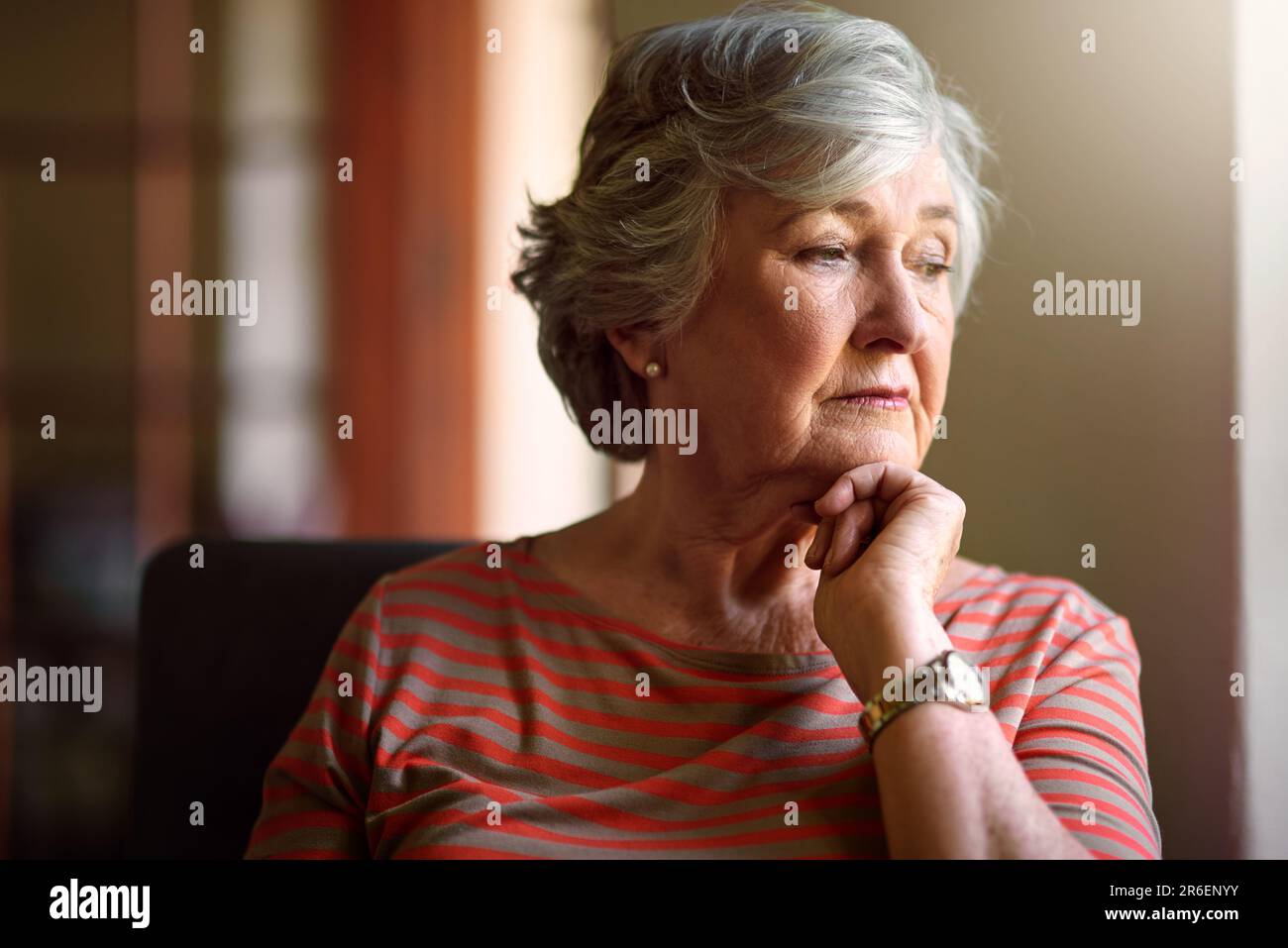 Senior woman, worry and thinking at window with memory, ideas and home on living room sofa ...
