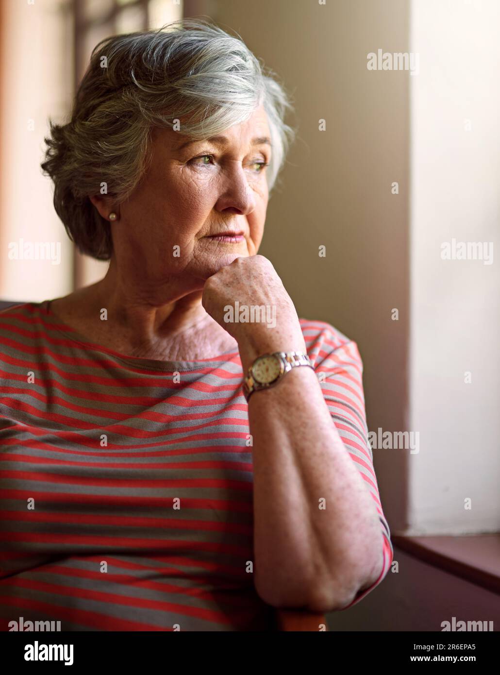 Senior woman, sad and thinking at window for memory, ideas and home on living room sofa. Elderly ...