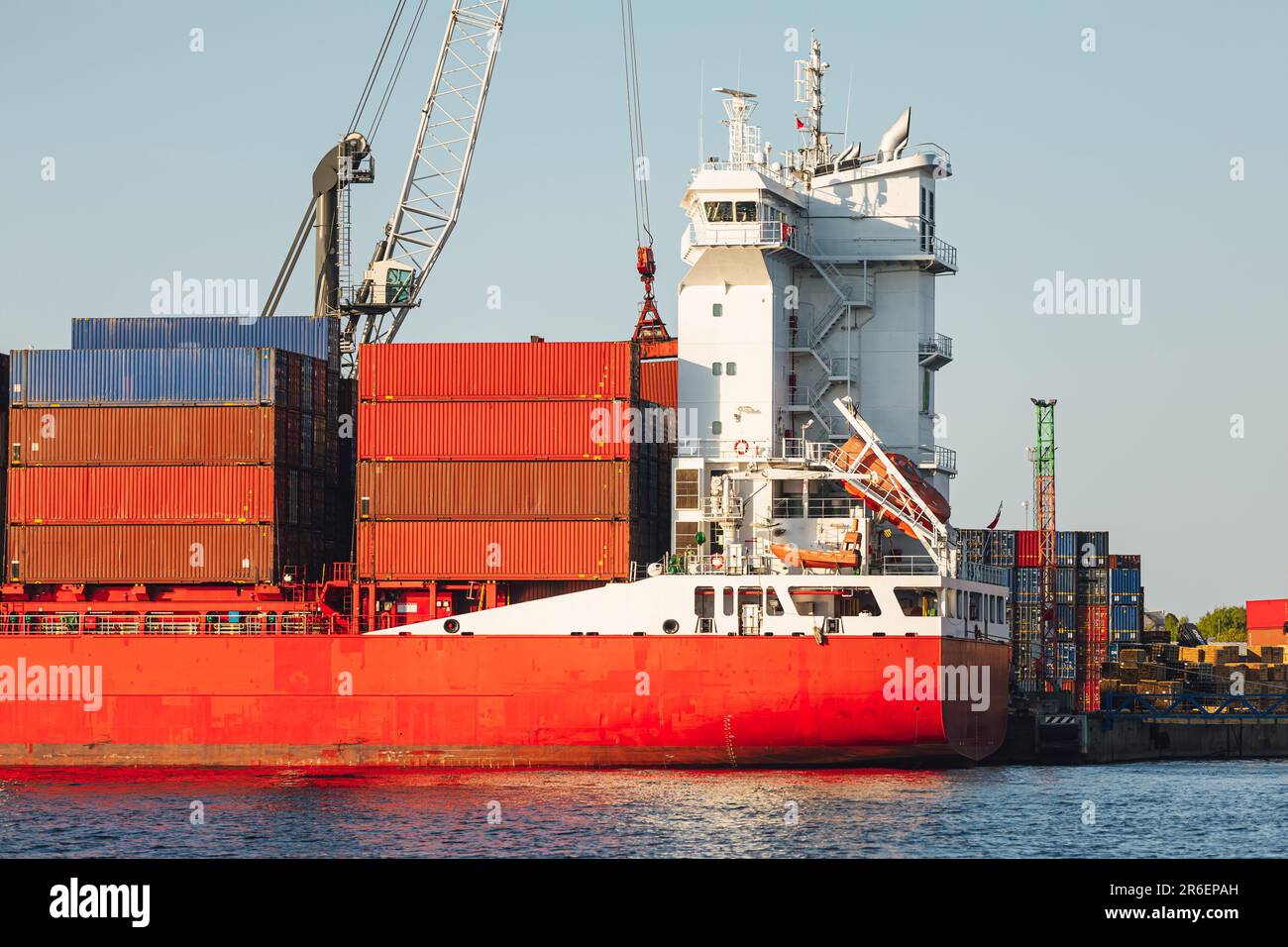 A large industrial vessel, with several cargo containers on the edge of ...