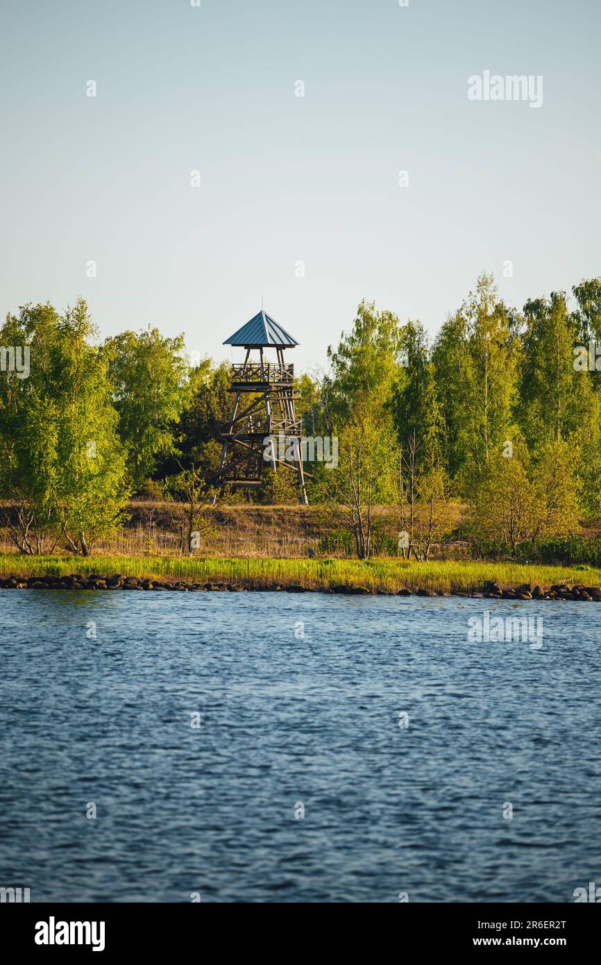 An observation tower stands atop a small island, with lush trees in the ...