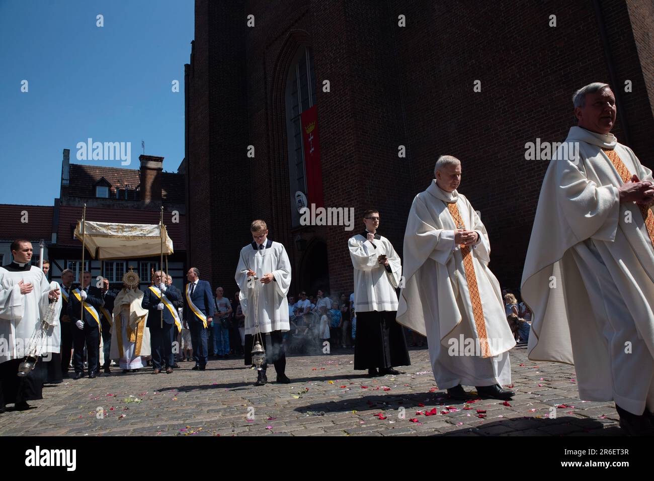 Priests in liturgical vestments begin the procession carrying the ...