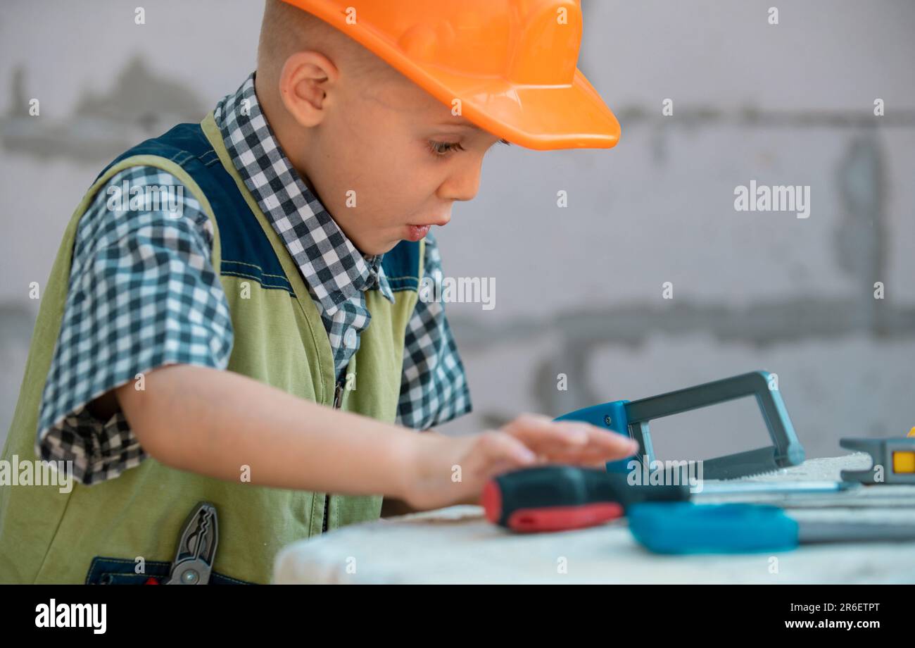 Preschool boy trying to saw, Child sawing on a construction site near ...