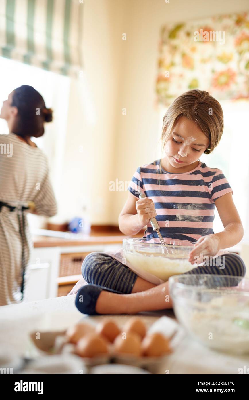 Mom, mixing or girl child baking in kitchen as a family with kid ...