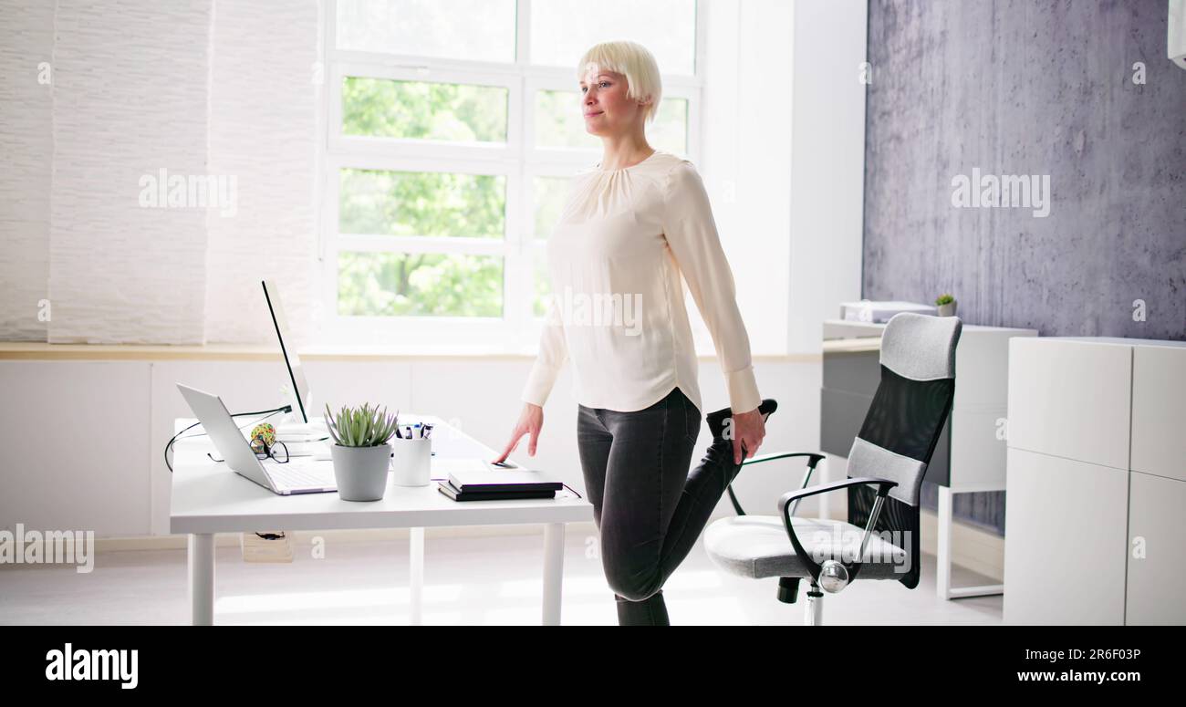 Yoga Workout In Office Behind Business Computer. Gymnastics And Leg ...