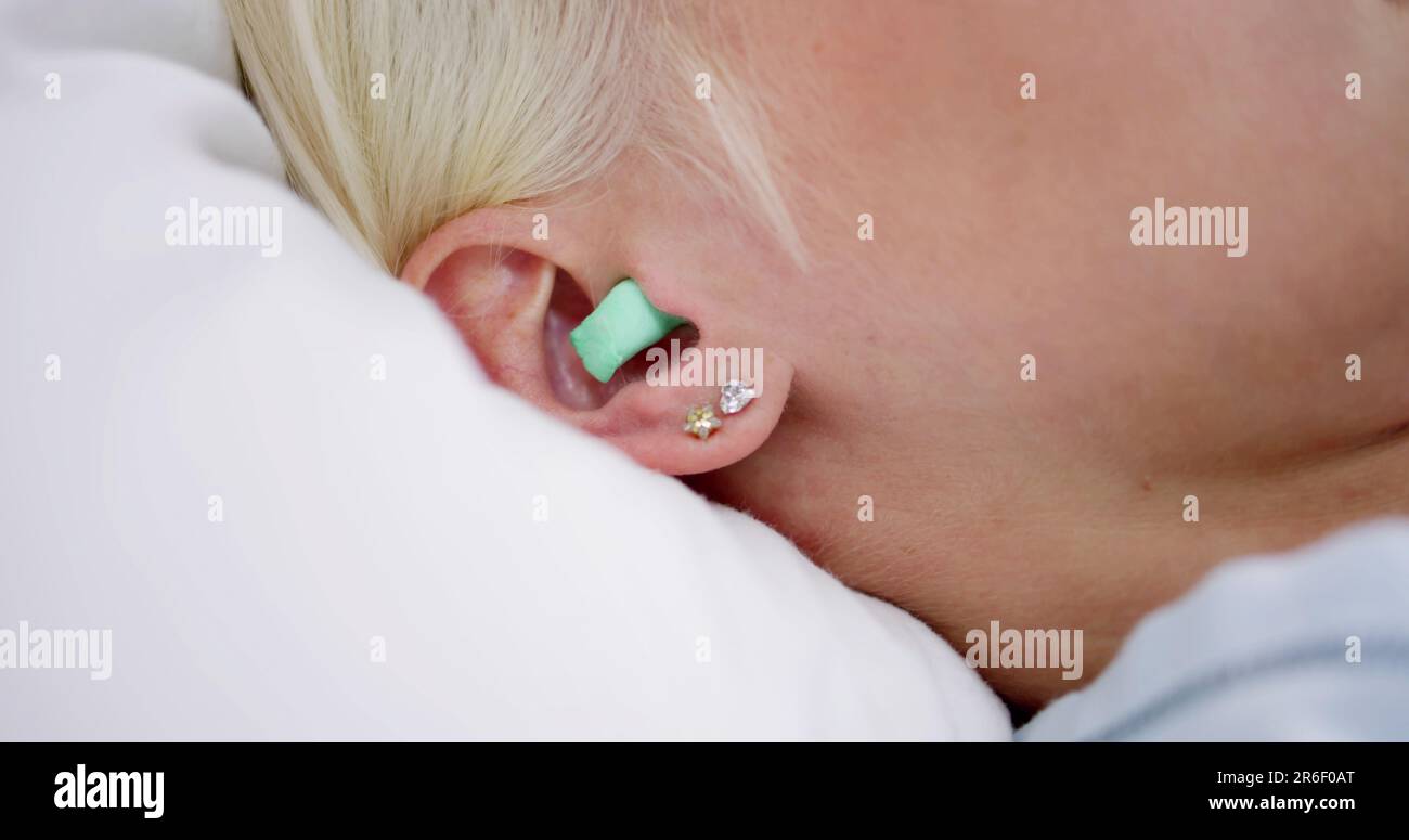Woman Sleeping With Earplugs In Her Ears In Bed Stock Photo - Alamy