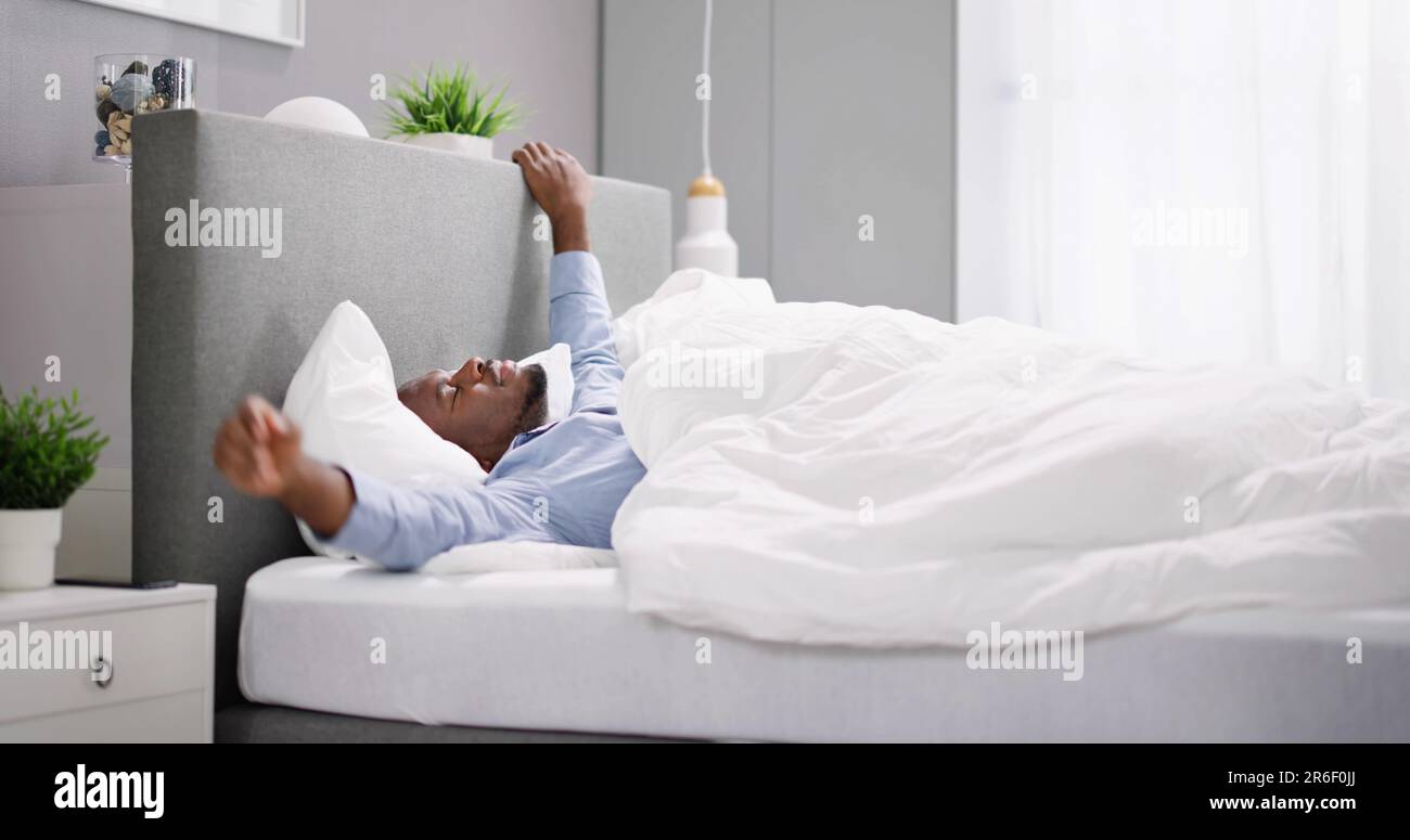 Yawning African American Man Sleeping In Bed Stock Photo - Alamy