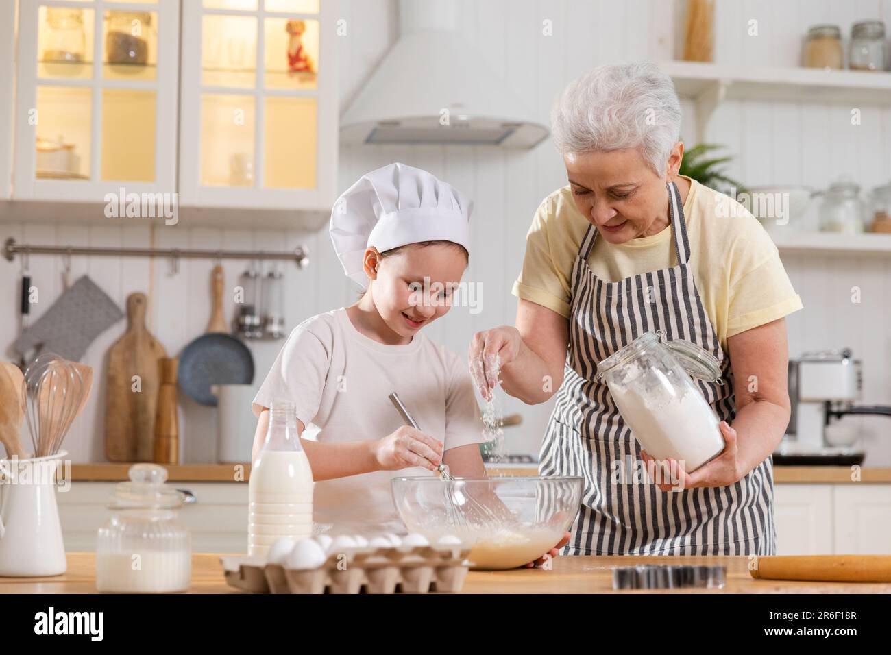 Happy family in kitchen. Grandmother and granddaughter child cook in ...