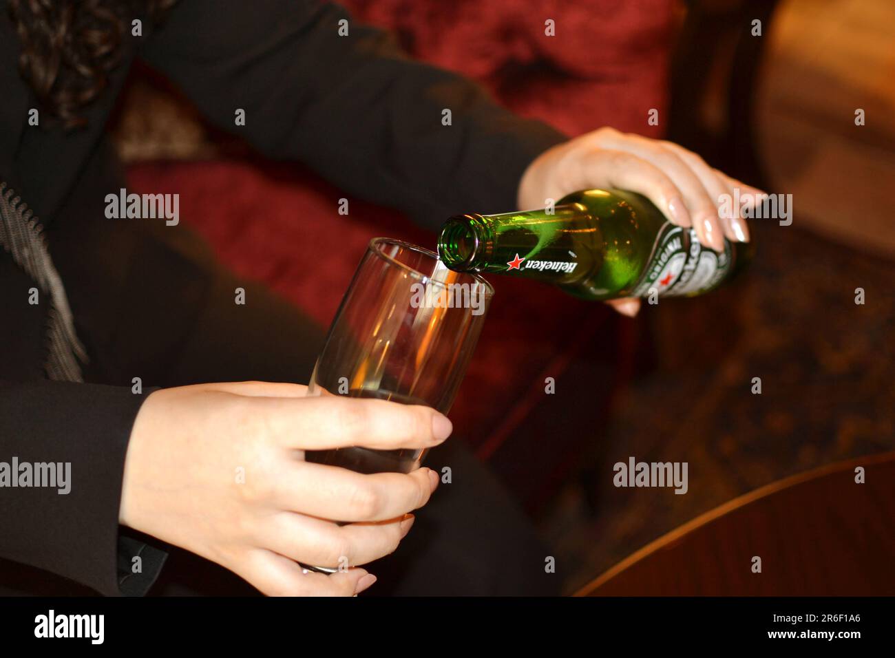 A lady pouring Heineken beer in a glass while sitting in a bar Stock ...