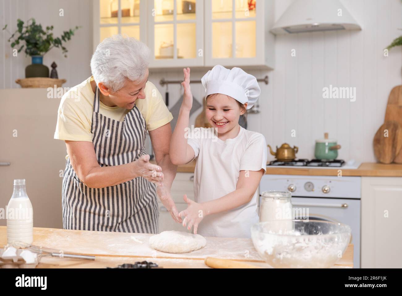 Happy family in kitchen. Grandmother and granddaughter child cook in ...