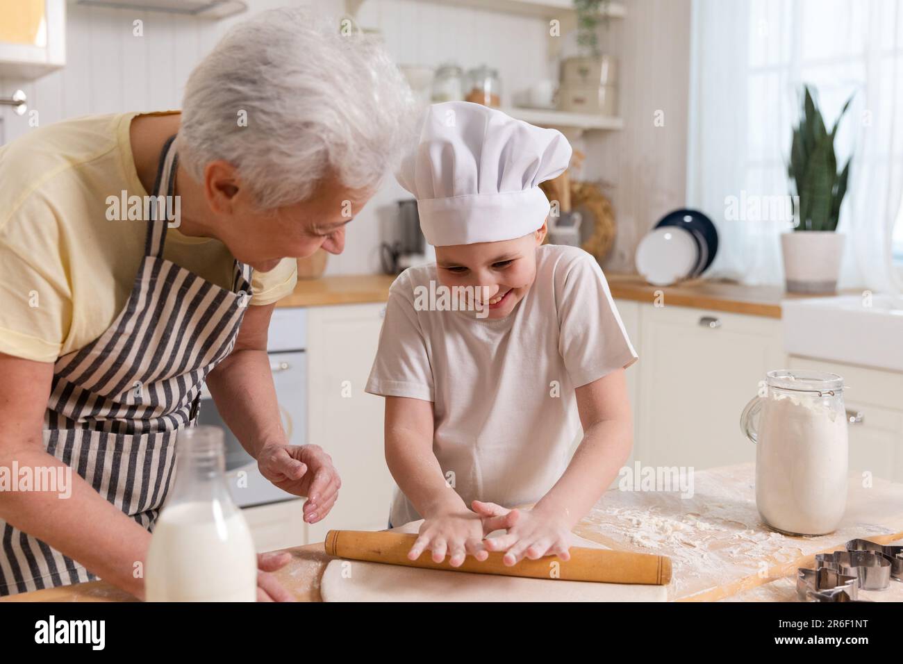 Happy family in kitchen. Grandmother and granddaughter child cook in ...