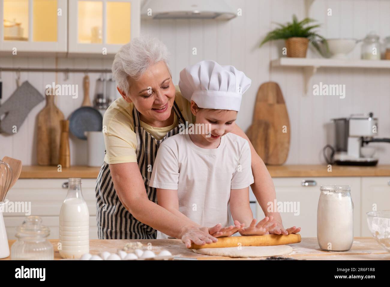 Happy family in kitchen. Grandmother and granddaughter child cook in ...