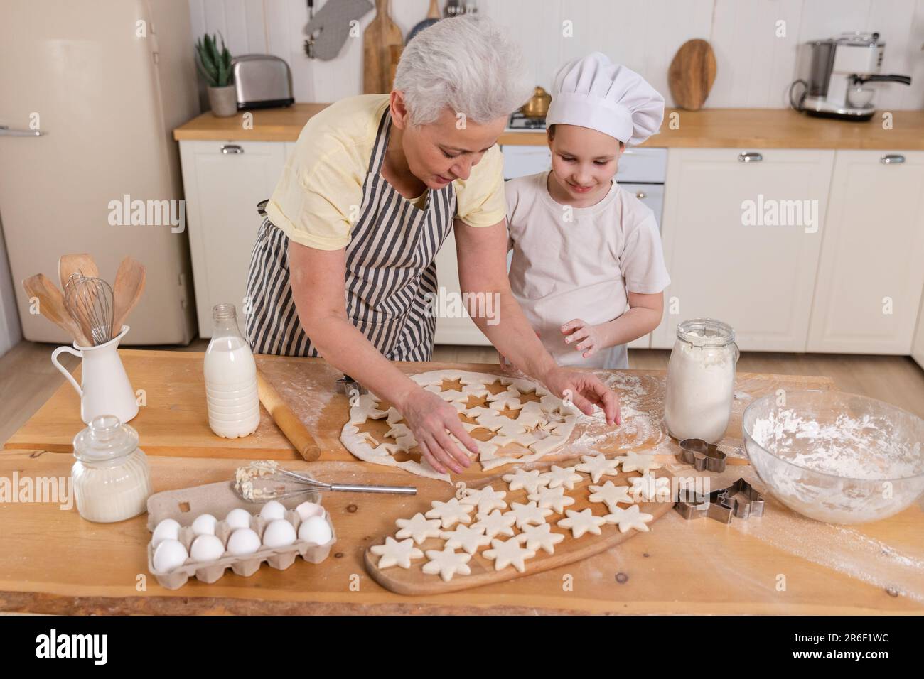 Happy family in kitchen. Grandmother granddaughter child cutting ...