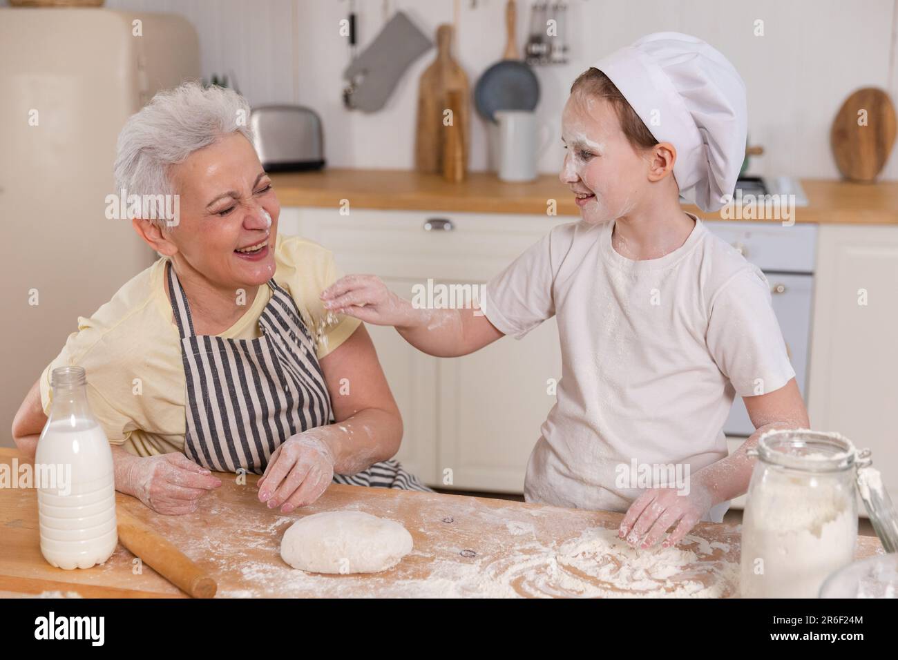 Happy family in kitchen. Grandmother and granddaughter child cook in ...