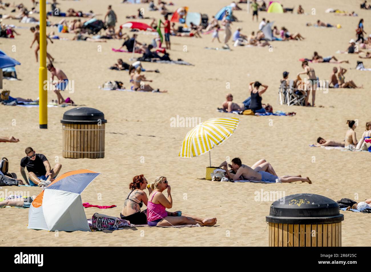 SCHEVENINGEN - Beachgoers enjoy the beautiful weather on the beach of ...