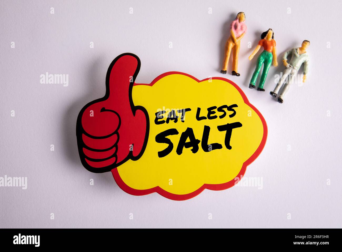 Eat Less Salt. Sticky note with text and miniature human figures on a ...