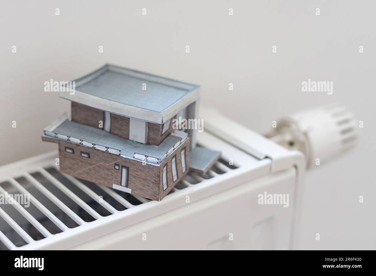 Model of house on white radiator Stock Photo - Alamy
