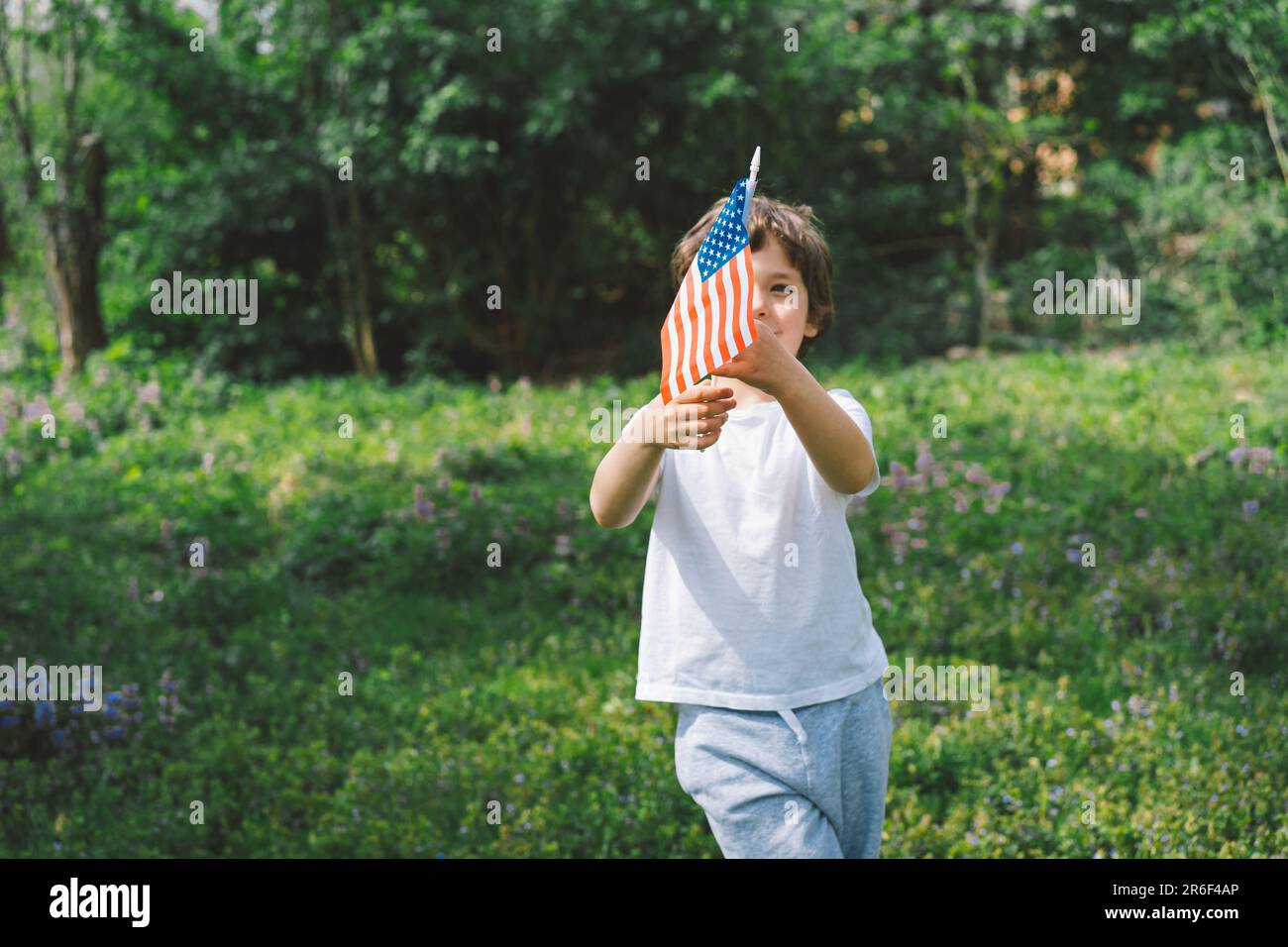 Happy little patriotic boy holding American flag Stock Photo - Alamy