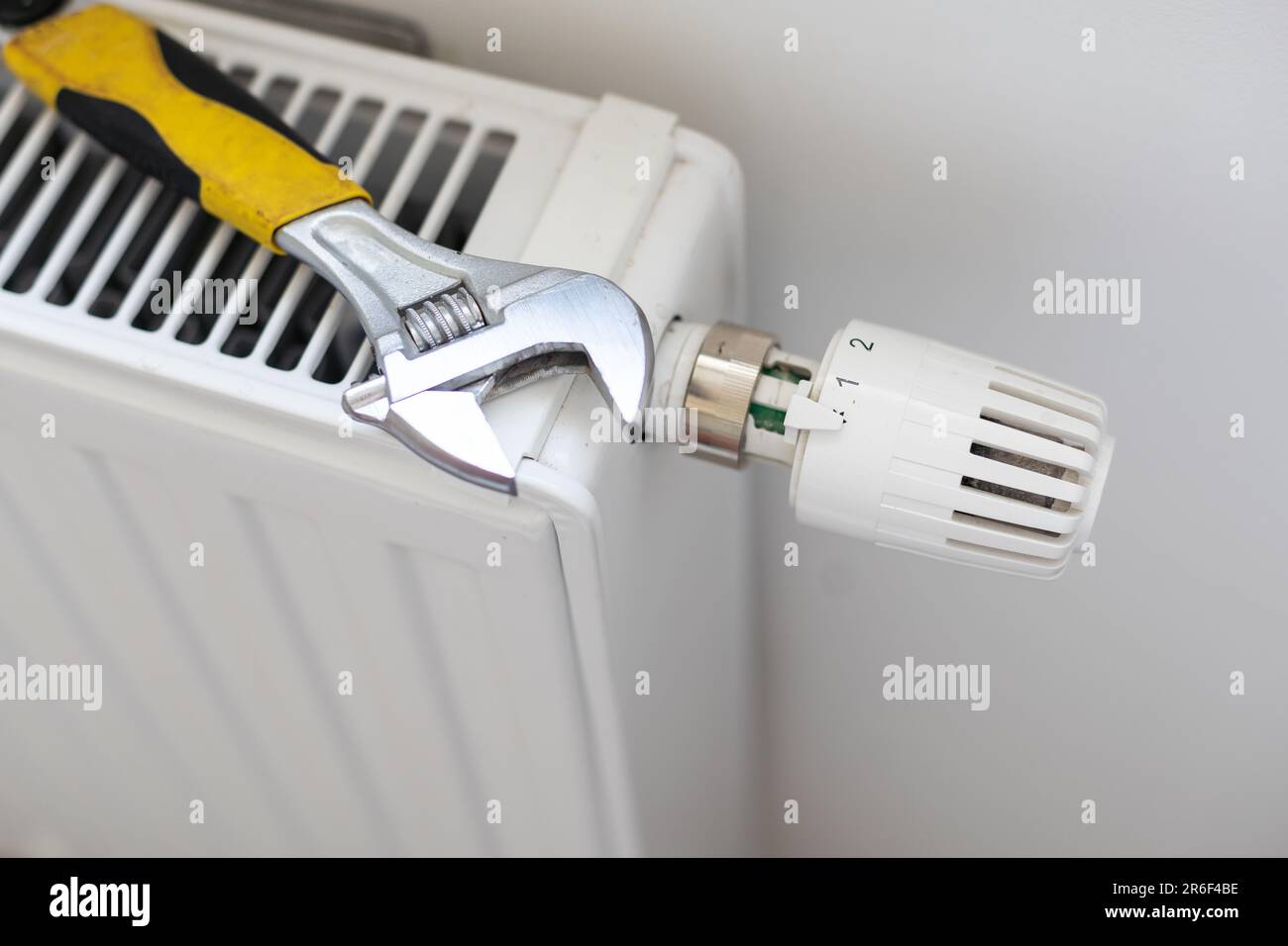 Worker hands repairing radiator with wrench. Close-up.Removing air from ...