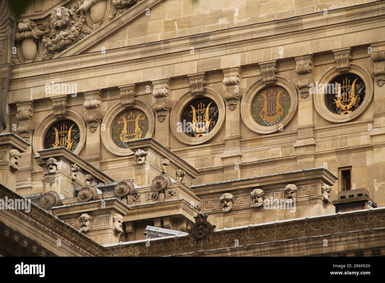 A close-up view of a traditional analog clock attached to the side of a ...