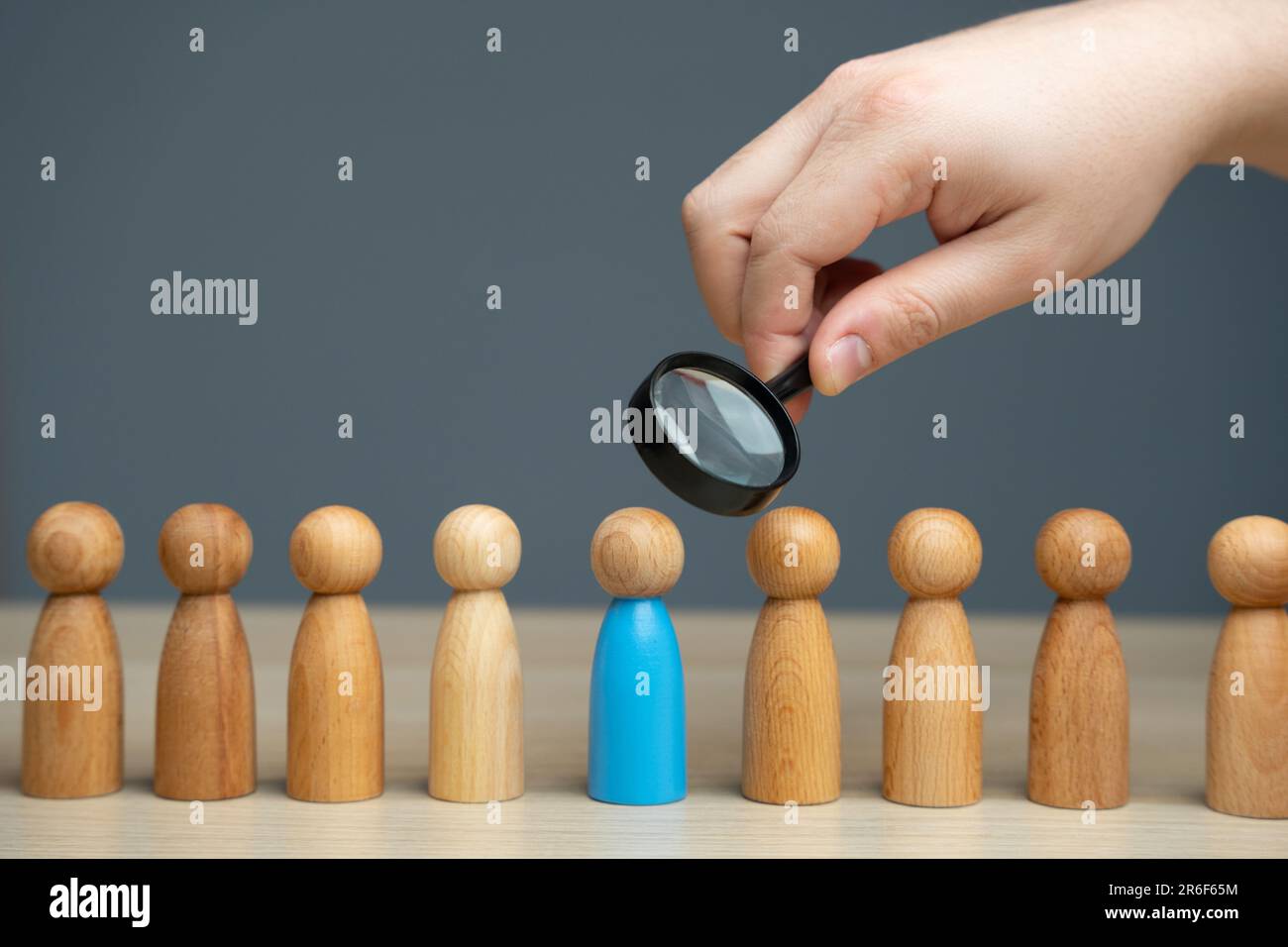 A businessman looks through a magnifying glass at a business team ...