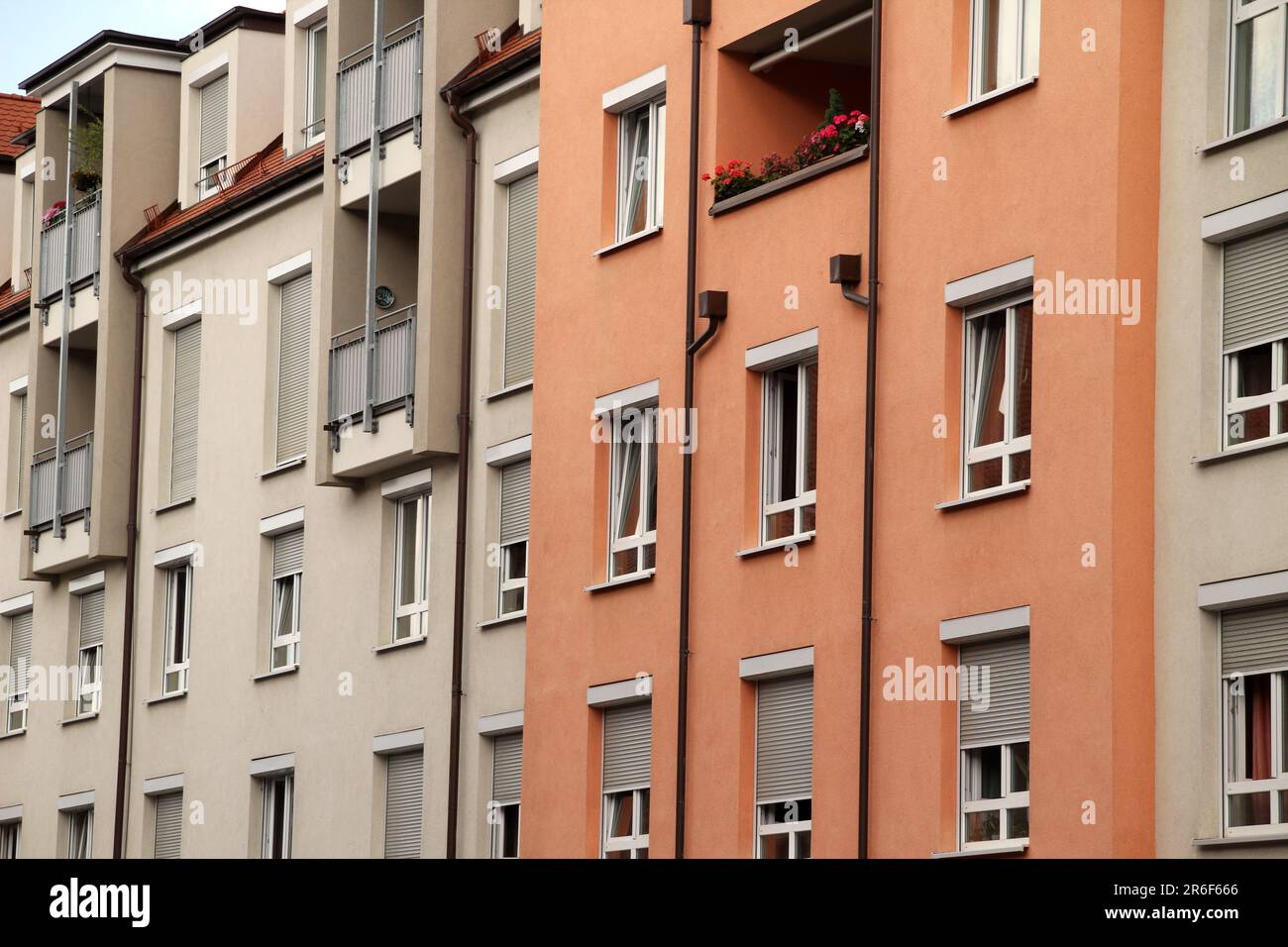 A high-rise street scene featuring a vibrant red building standing out ...