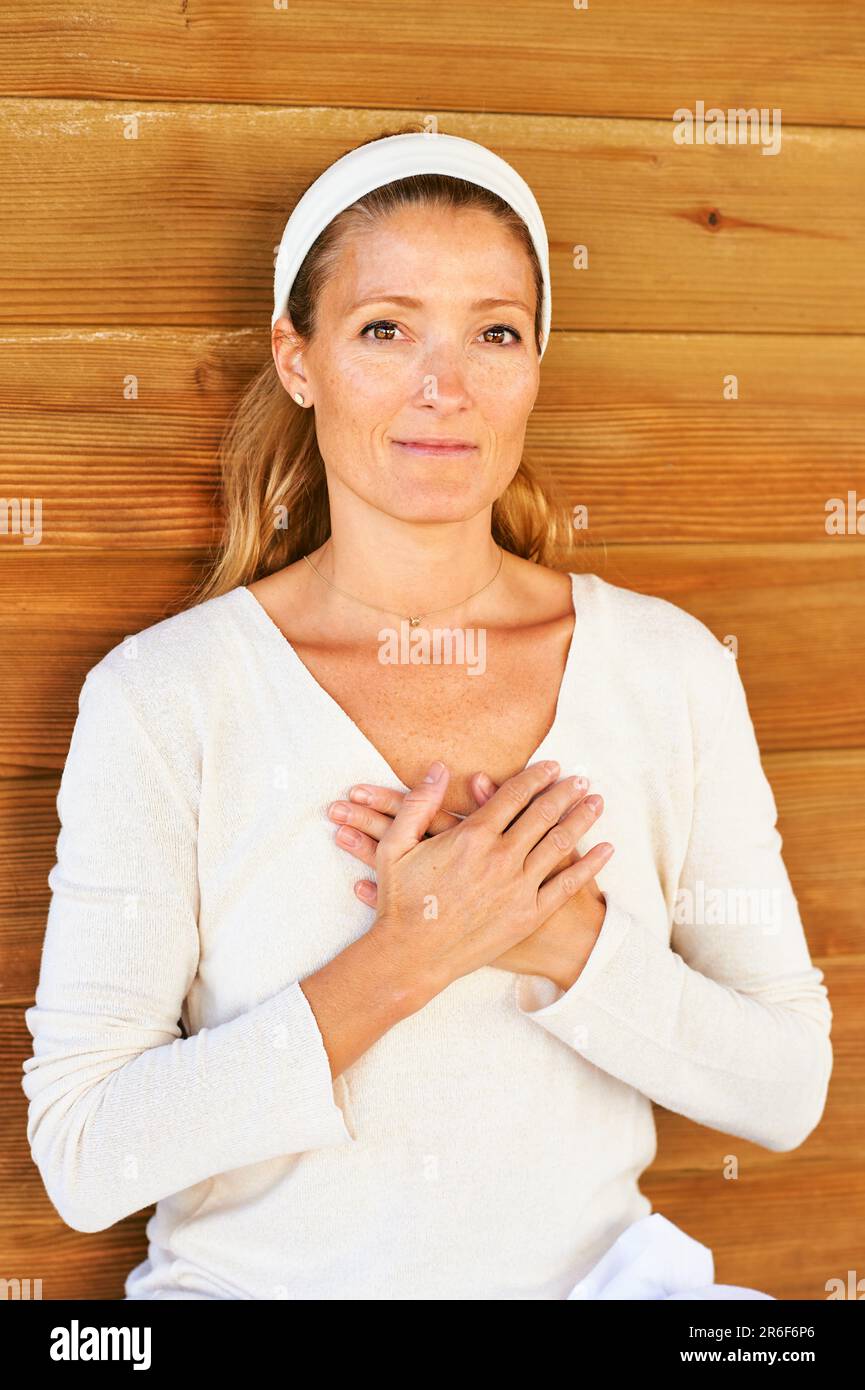 Outdoor portrait of beautiful woman against wooden background, holding ...