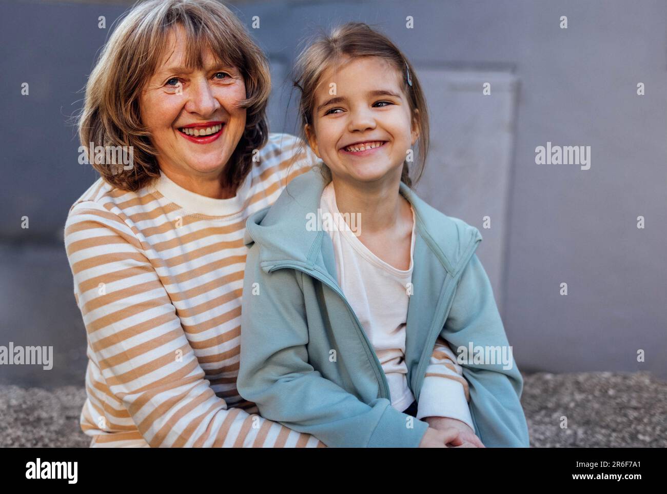 Little girl hugging smiling middle aged woman. Cute female kid and her ...