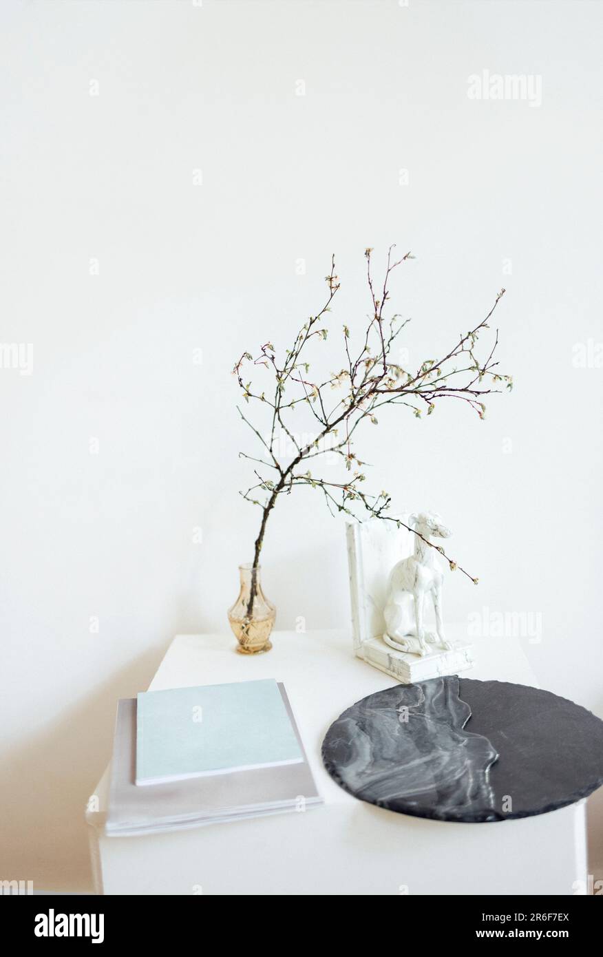 Square white wooden table with acrylic round painting, notebooks, glass ...
