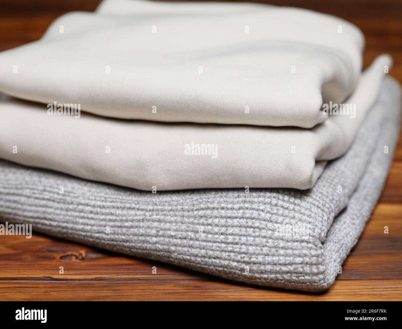a stack of folded white sheets on top of a wooden floor Stock Photo - Alamy