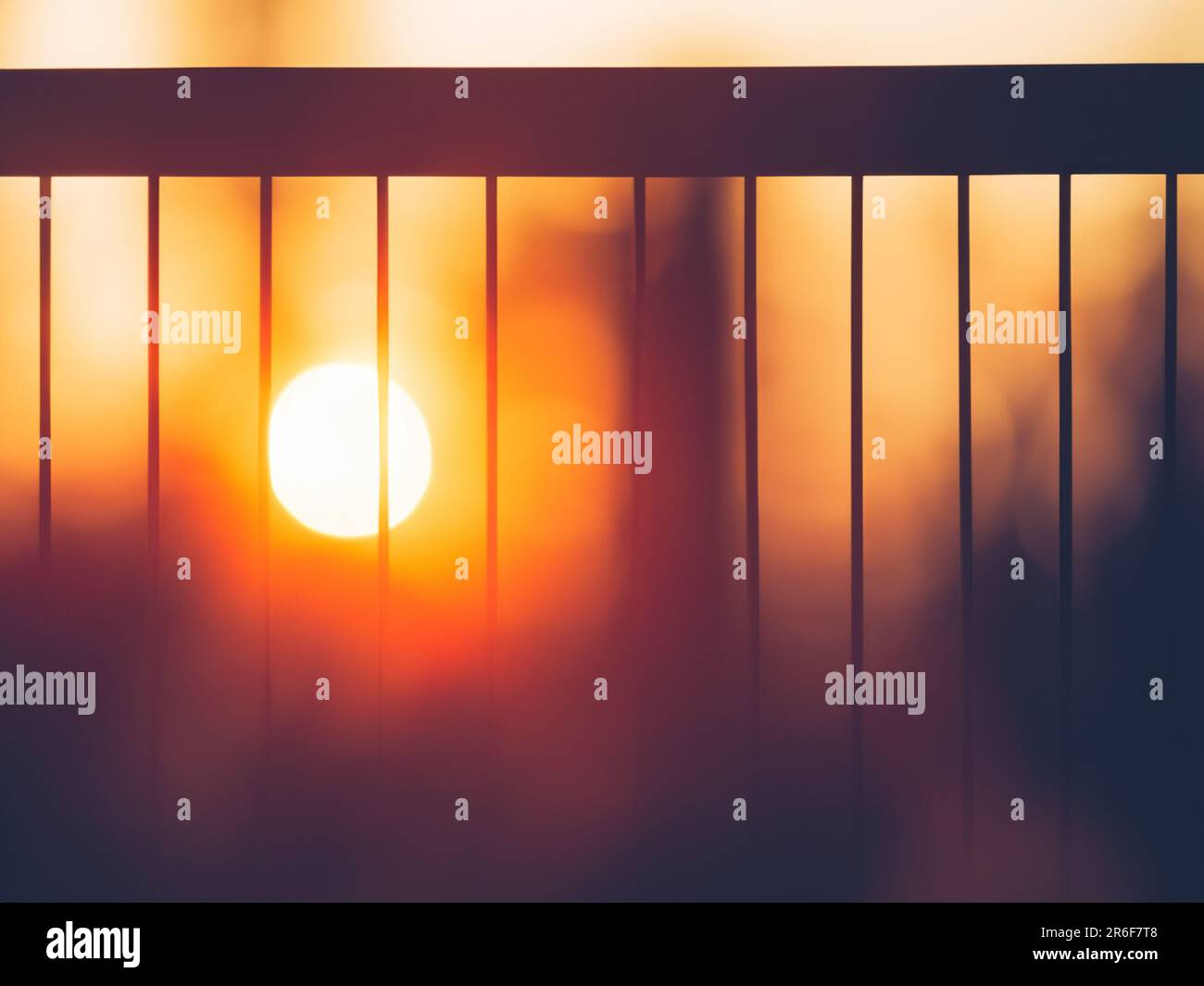 the sun is setting through the bars of a window sill Stock Photo - Alamy