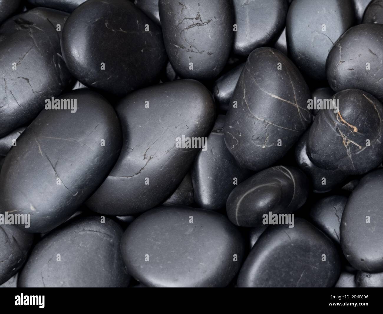 a pile of black rocks sitting next to each other on top of each other ...