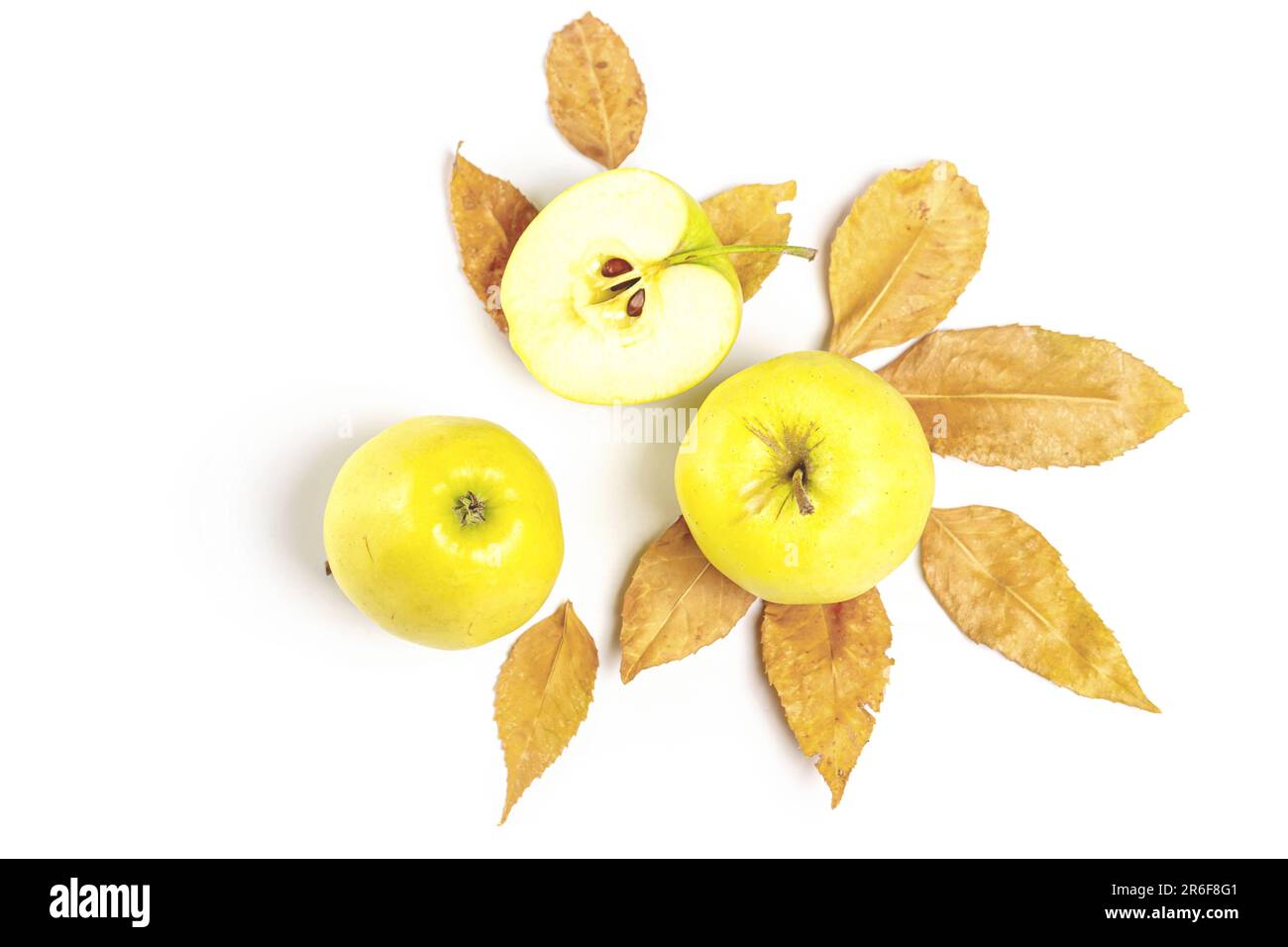 Three apples and green leaves arranged in a circular shape on a white ...