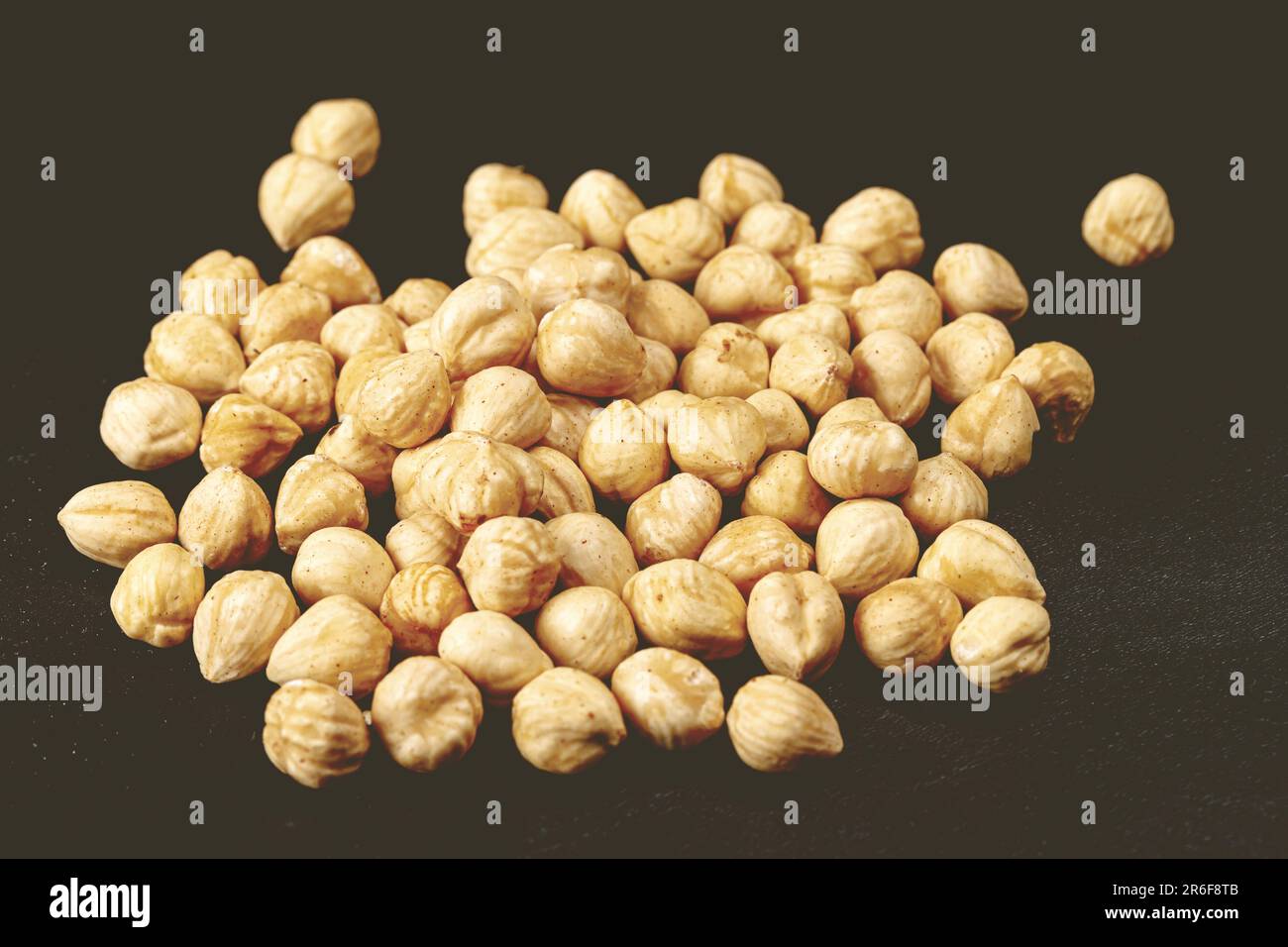 A pile of assorted nuts randomly cascading onto a black background ...