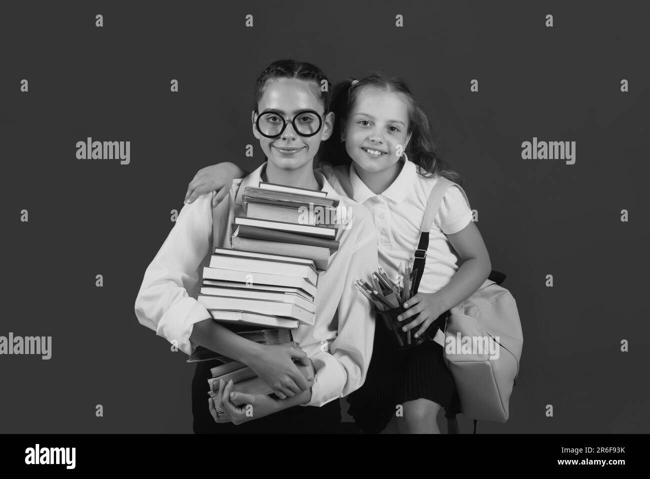 Little school girl with pile of books. Teen student carry a book. Hard ...