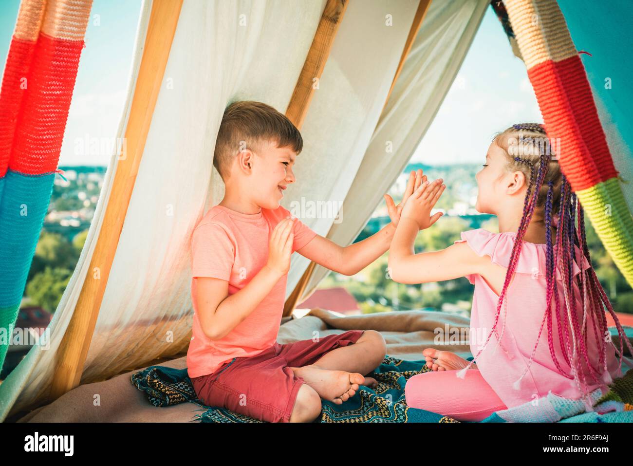 Brother and sister playing together. Happy kids family playing in tent ...