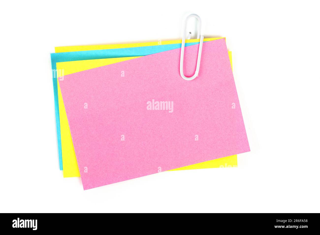 A close-up shot of post-it notes stuck onto a metal clip on a white ...