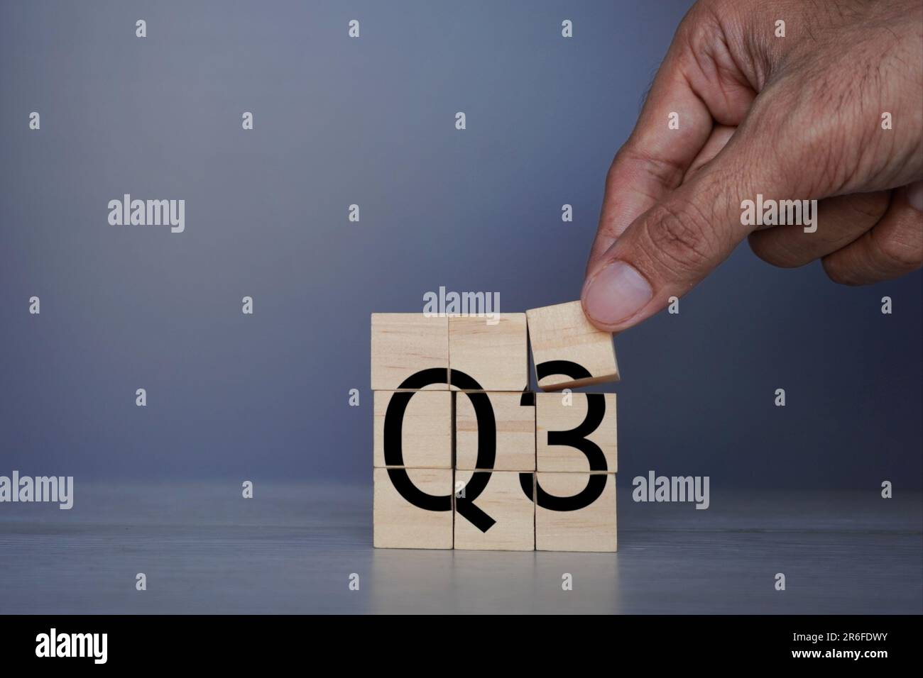 Hand placing wooden cube with text Q3. Third quarter business concept ...
