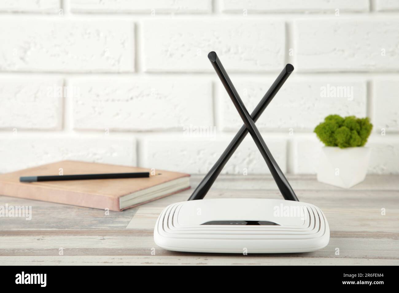 Wireless Wi-Fi router on blue background with notebook on beige. Top ...