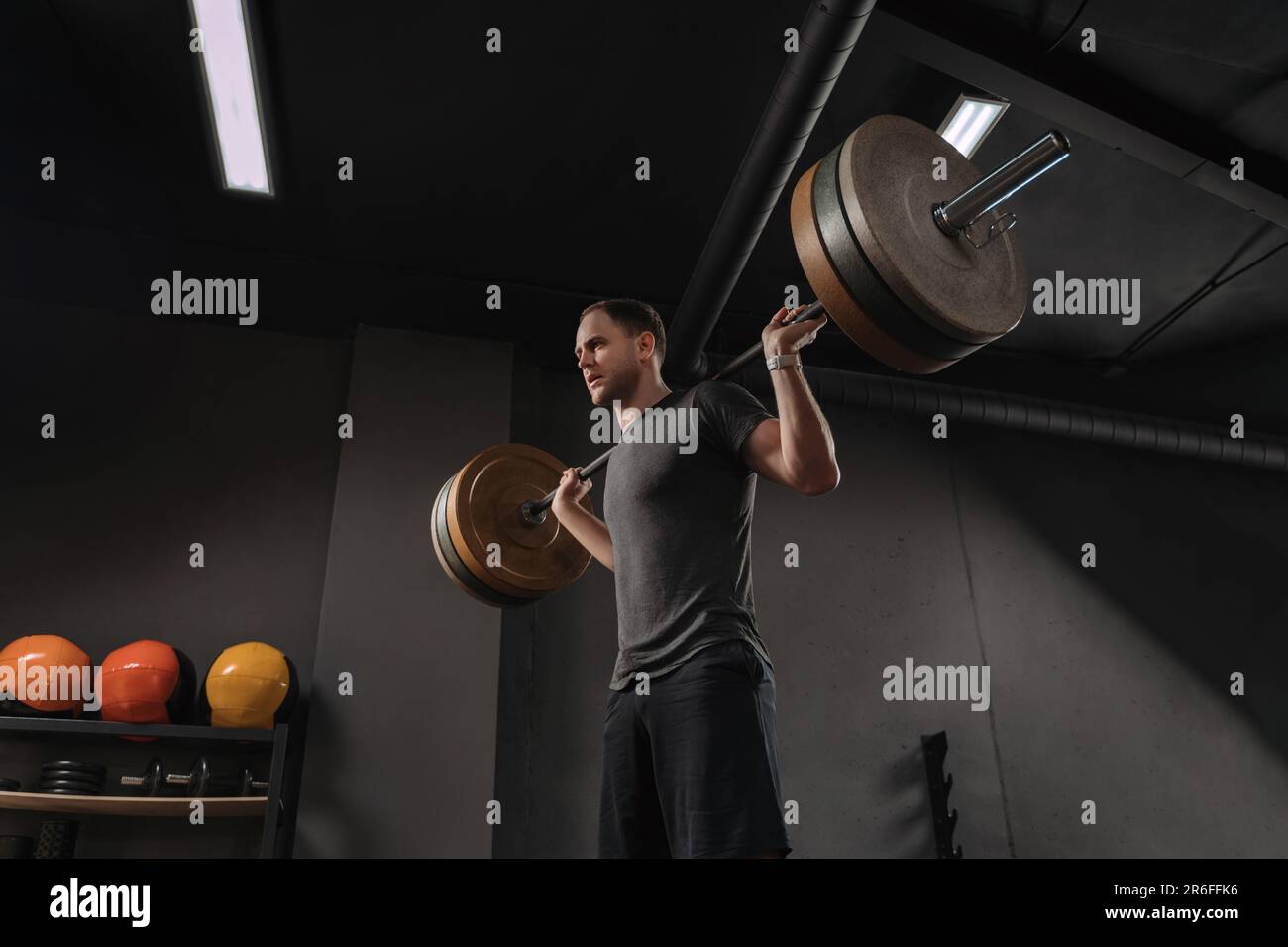 Fitness man doing weight training with barbell. Young muscular athlete ...