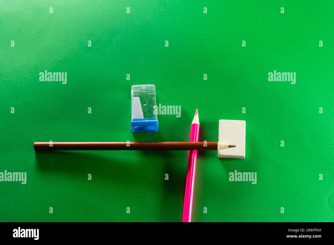 An assortment of pencils with rubber and eraser on a vibrant green ...
